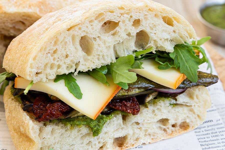 Ciabatta sandwich with roasted vegetables, pesto, and Pavé d’Isigny ...